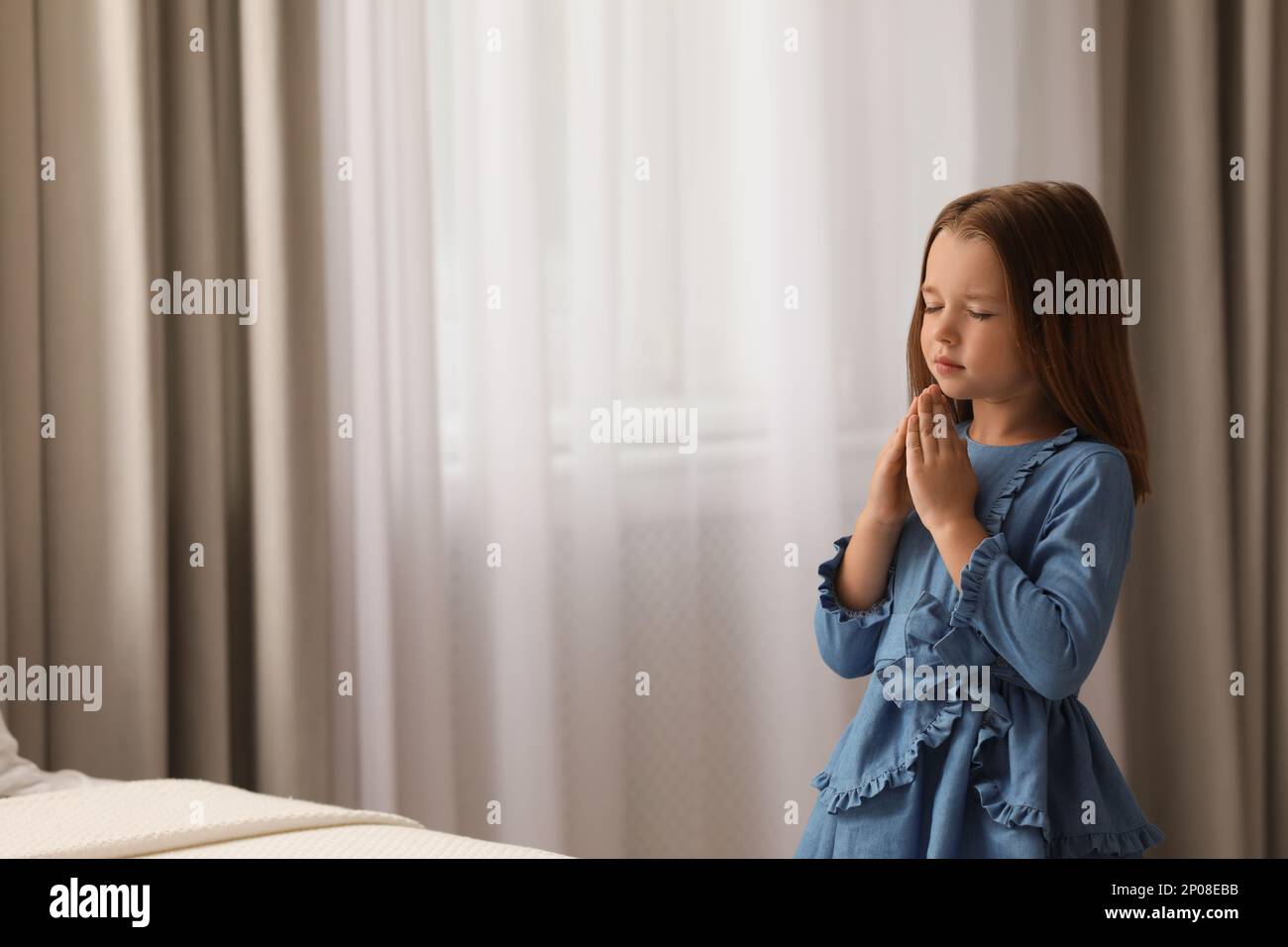 Cute little girl saying bedtime prayer at home. Space for text Stock ...