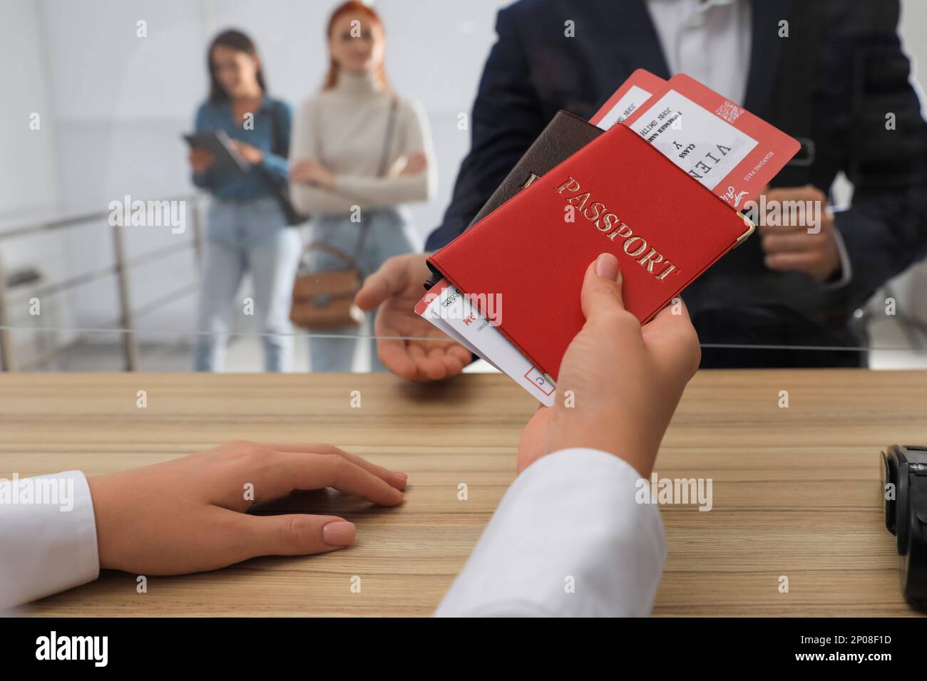 Agent giving passports with tickets to client at check-in desk in ...