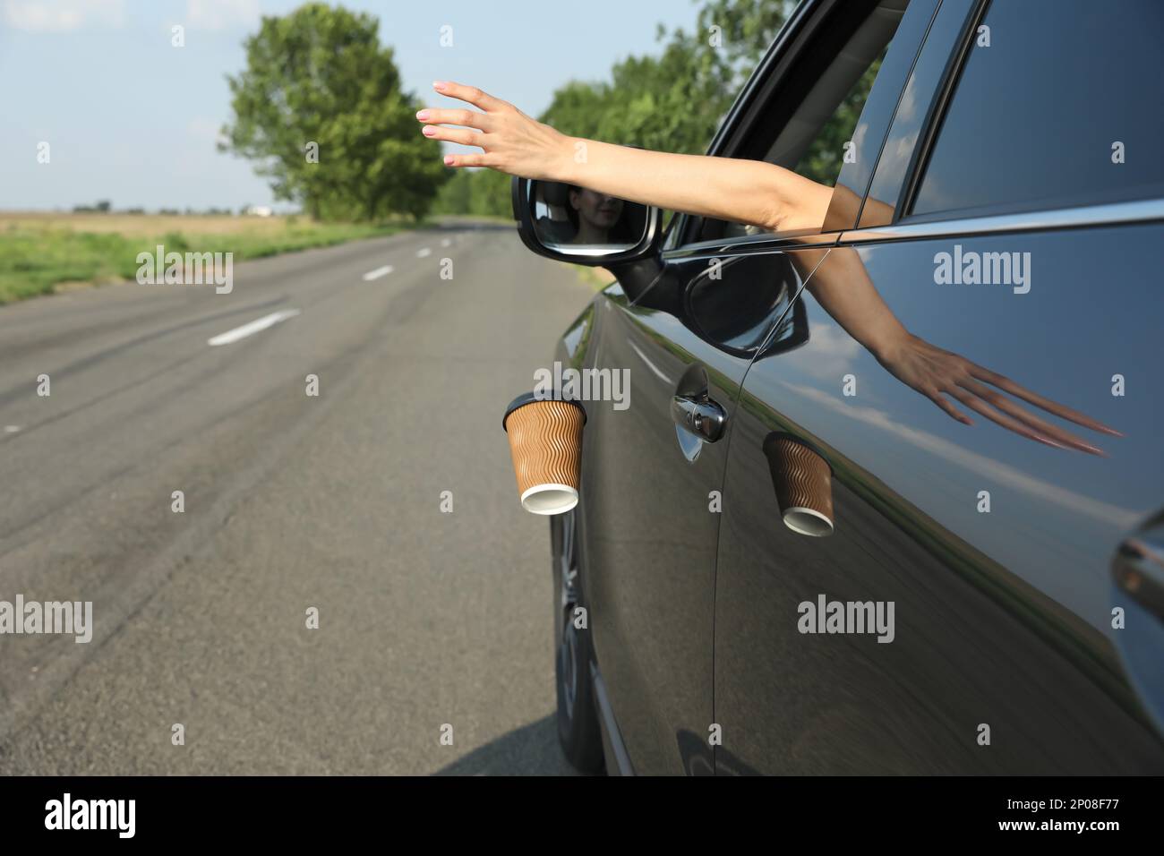 Driver throwing away paper cup from car window. Garbage on road Stock ...