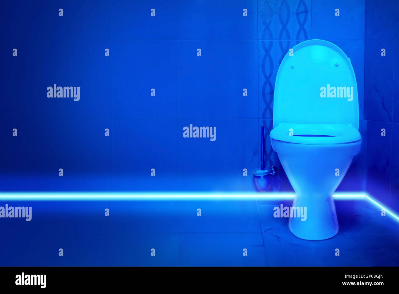 Toilet bowl in public restroom lit with UV blue light Stock Photo Alamy