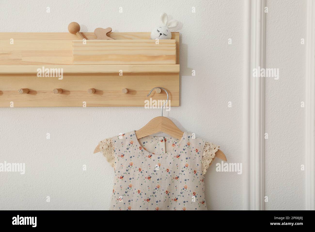 Wooden rack with cute dress in child room. Interior design Stock Photo ...