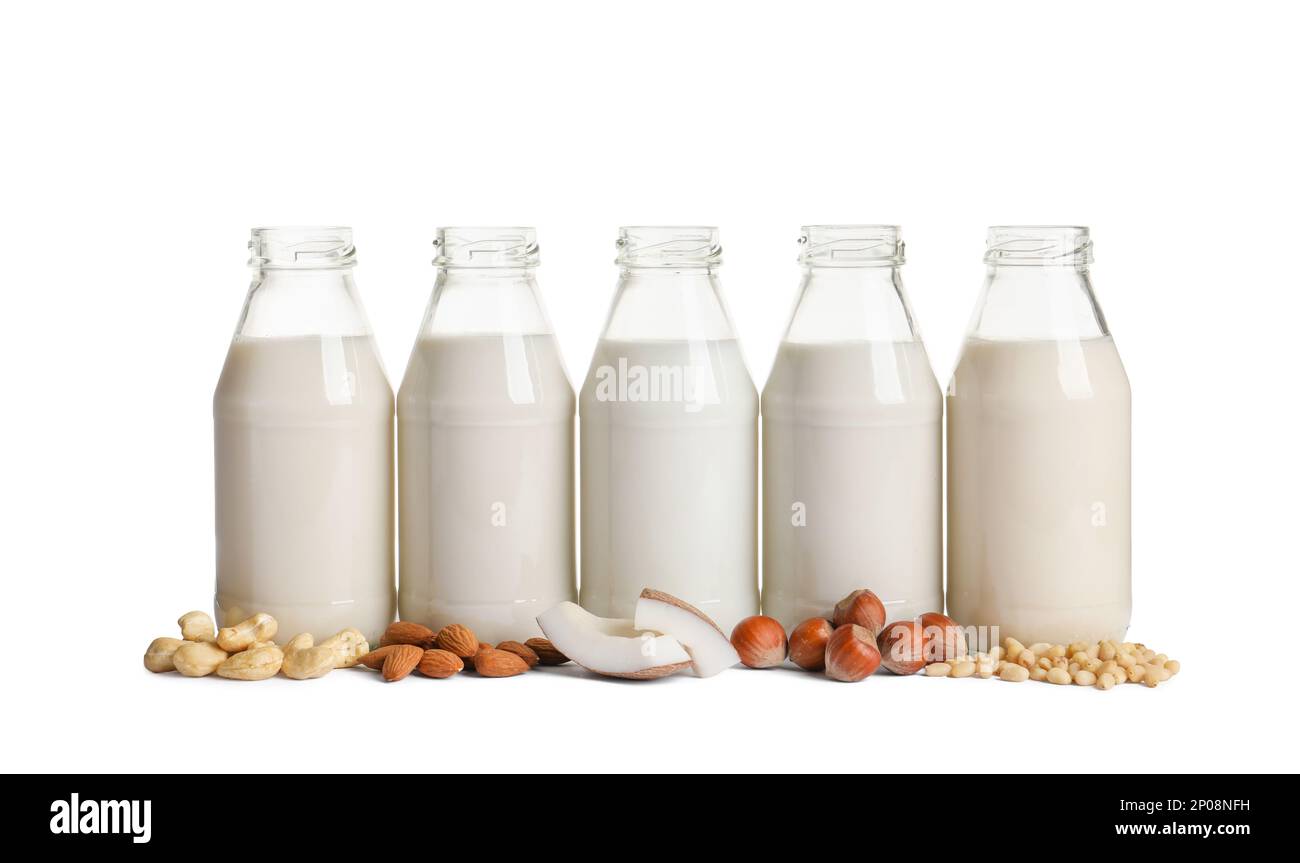 Vegan milk and different nuts on white background Stock Photo - Alamy