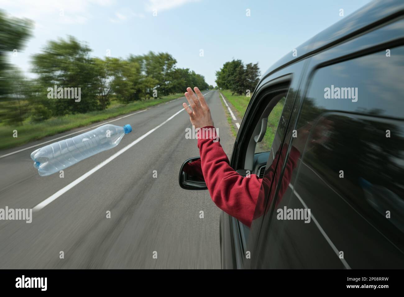 Driver throwing away plastic bottle from car window. Garbage on road ...
