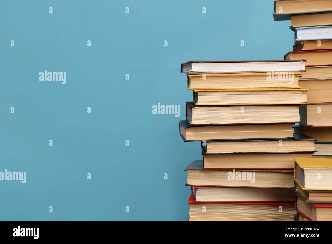 Many hardcover books on turquoise background, space for text. Library ...