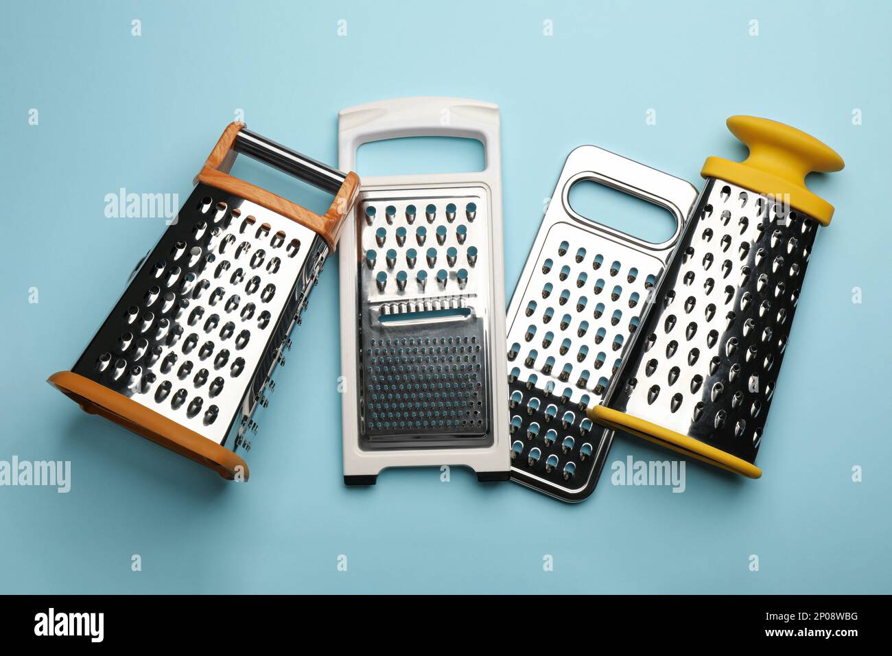 Different modern graters on light blue background, flat lay Stock Photo ...