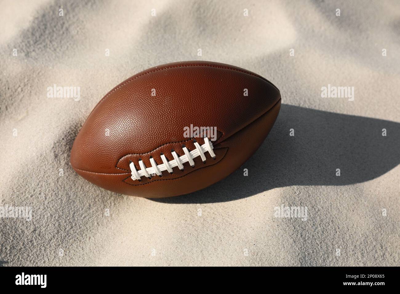 New leather American football ball on sand Stock Photo - Alamy