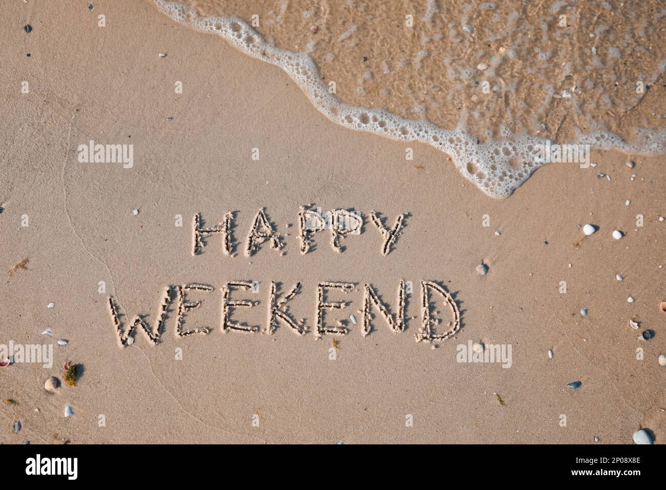Phrase Happy weekend written on sand at beach, top view Stock Photo - Alamy