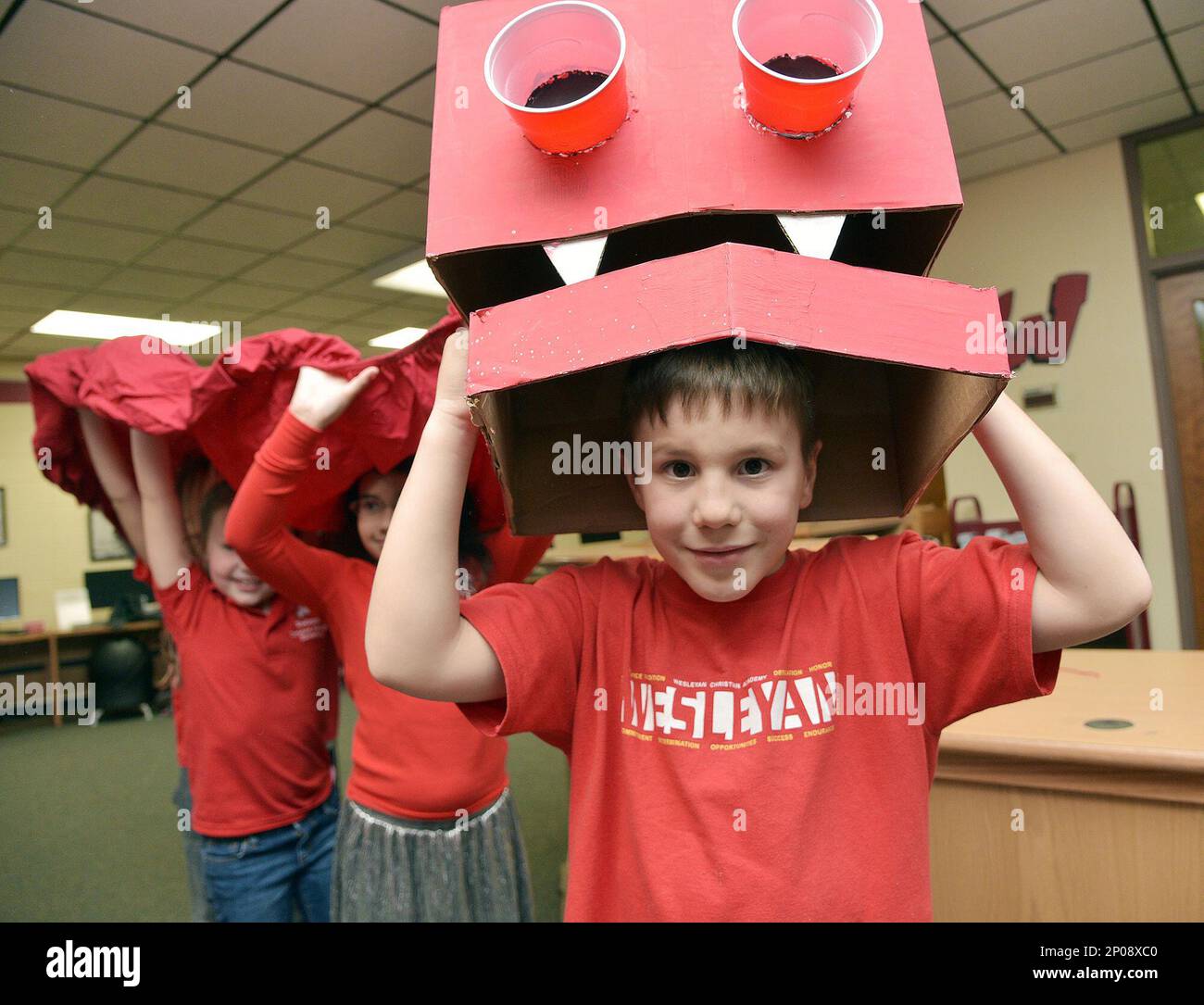 First-grader Maddox Enscore peaks out from under the head of the ...