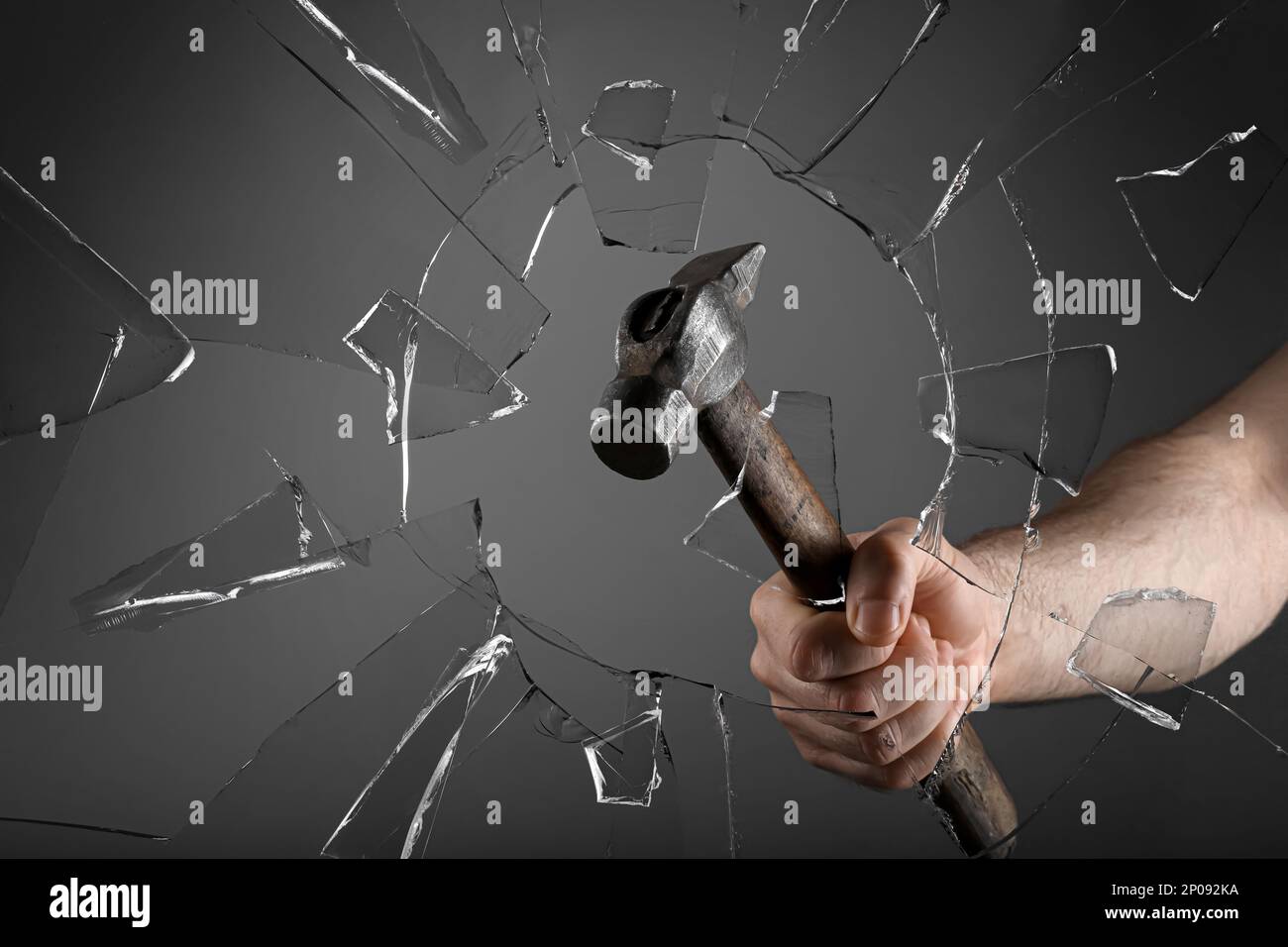 Man breaking window with hammer on dark grey background, closeup Stock ...