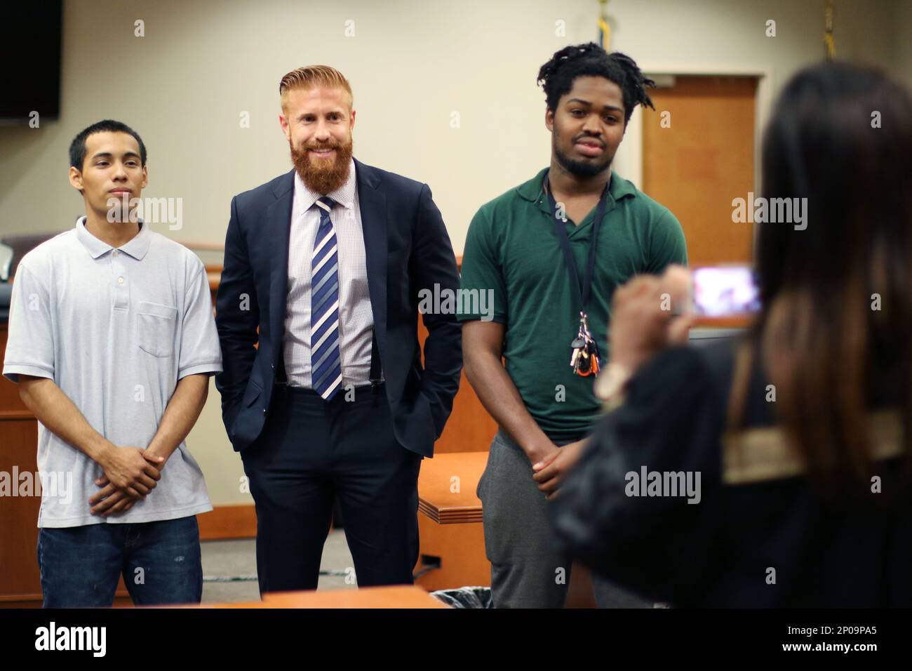 Lawyer David Lee Windecher, center, poses for a photo with two young ...