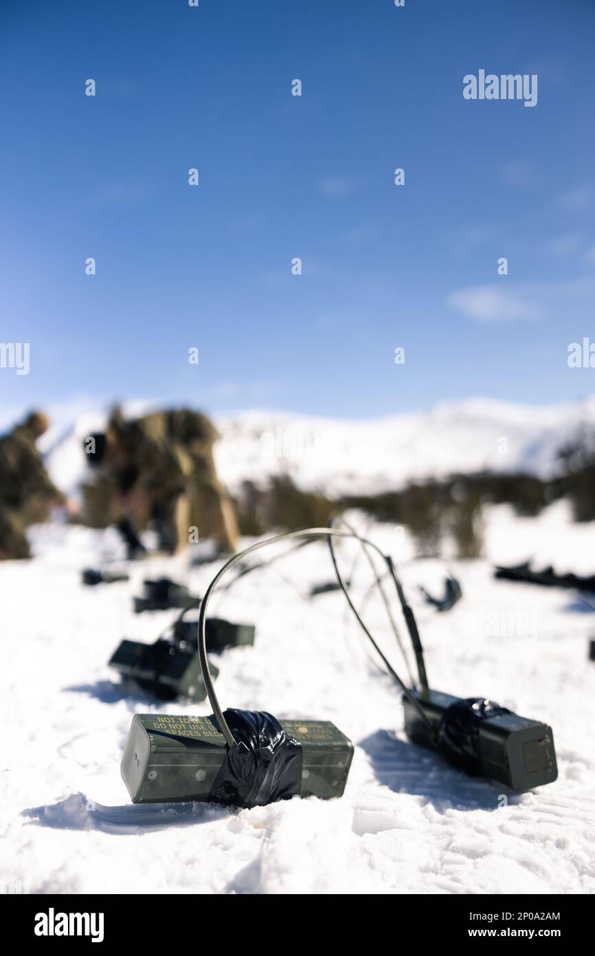 U.S. Marines attending the Winter Mountain Engineer Course, prepare explosives to trigger an ...