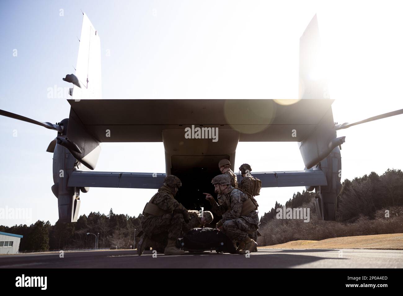U.S. Navy Corpsmen with 3d Battalion, 4th Marines load a simulated ...