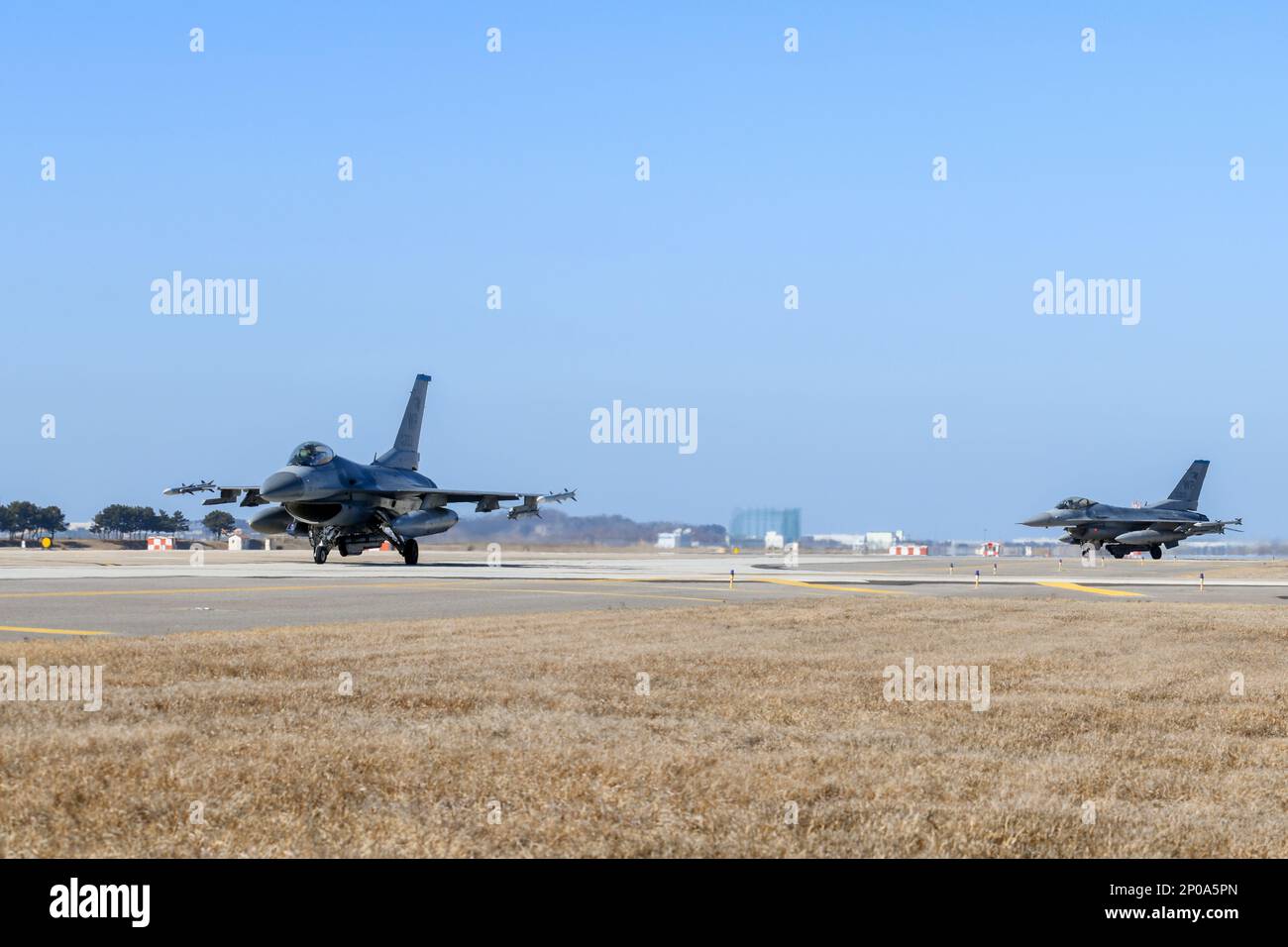 Two F-16 Fighting Falcons assigned to the 35th Fighter Squadron taxi ...