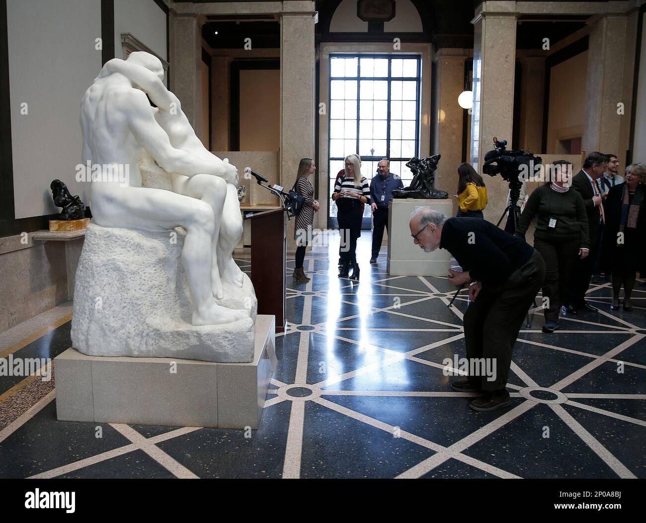 People gather around a copy of Rodin's "The Kiss" during a press ...