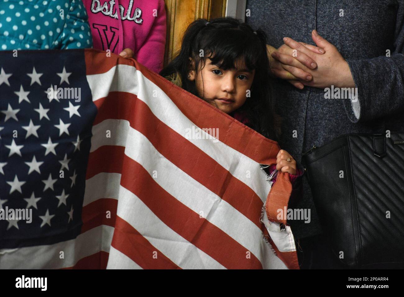 Maria Martinez, of Detroit, holds onto an American flag during a ...