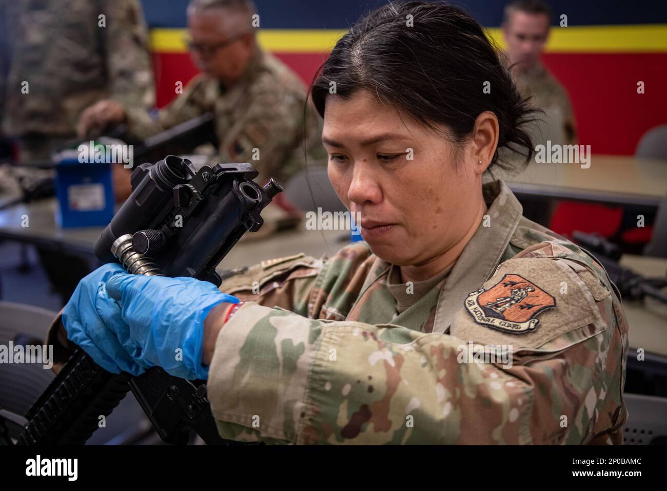 U.S. Air Force Chief Master Sgt. Bobbie Panger takes apart an M4 ...
