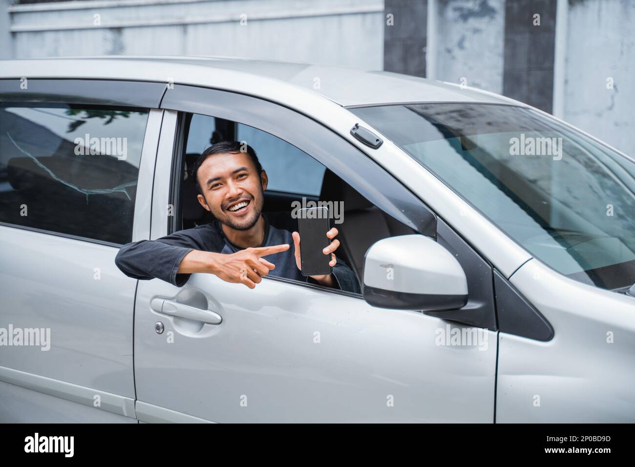 male driver pointing at cell phone screen in the car Stock Photo - Alamy