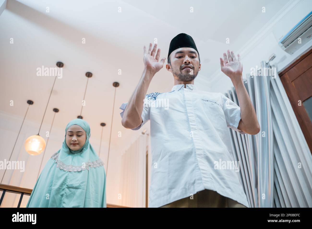 Asian Muslim men praying with women during I'tidal prayer movement ...