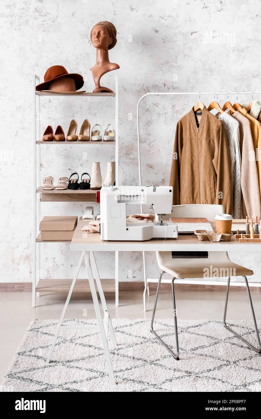 Interior of atelier with workplace, clothes and shelving unit Stock ...