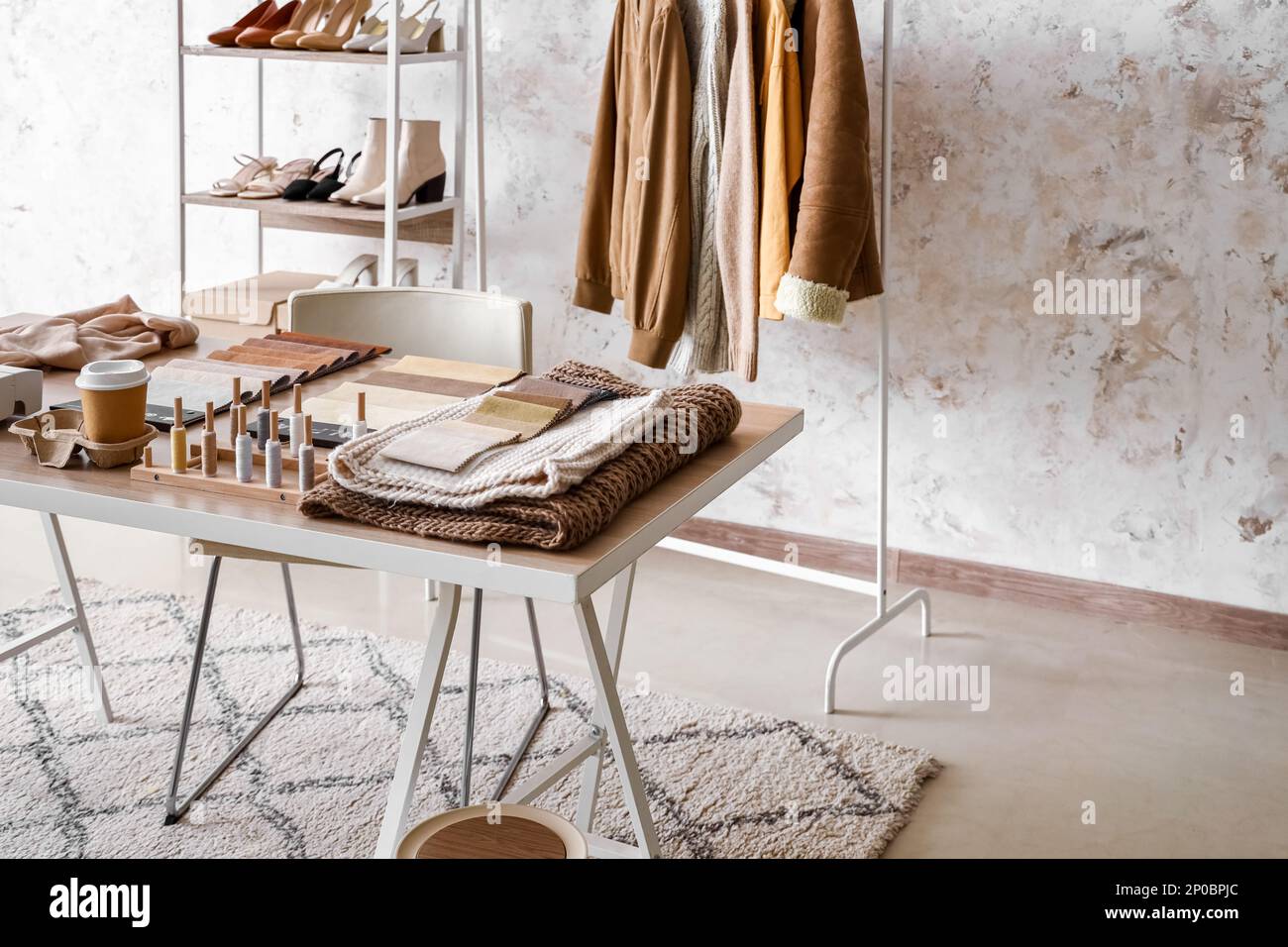 Interior of atelier with workplace, clothes and shelving unit Stock ...