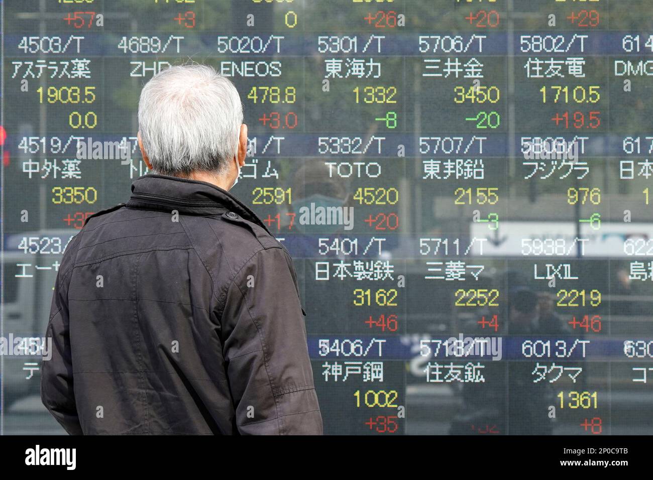 A person looks at an electronic stock board showing Japan's Nikkei 225 ...