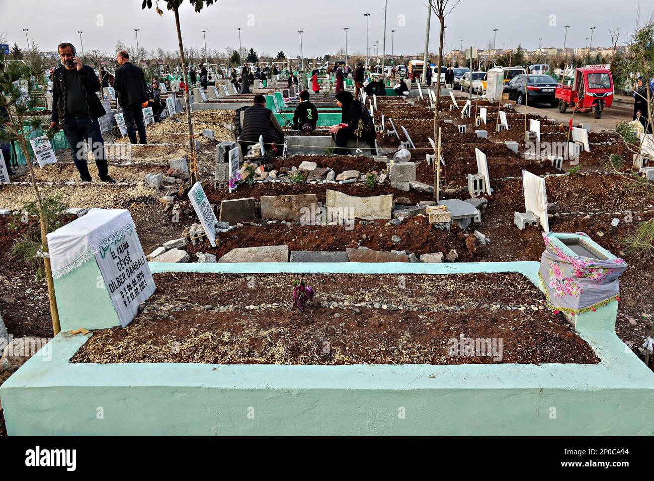 A praying family is seen at the cemetery and at the head of the grave ...