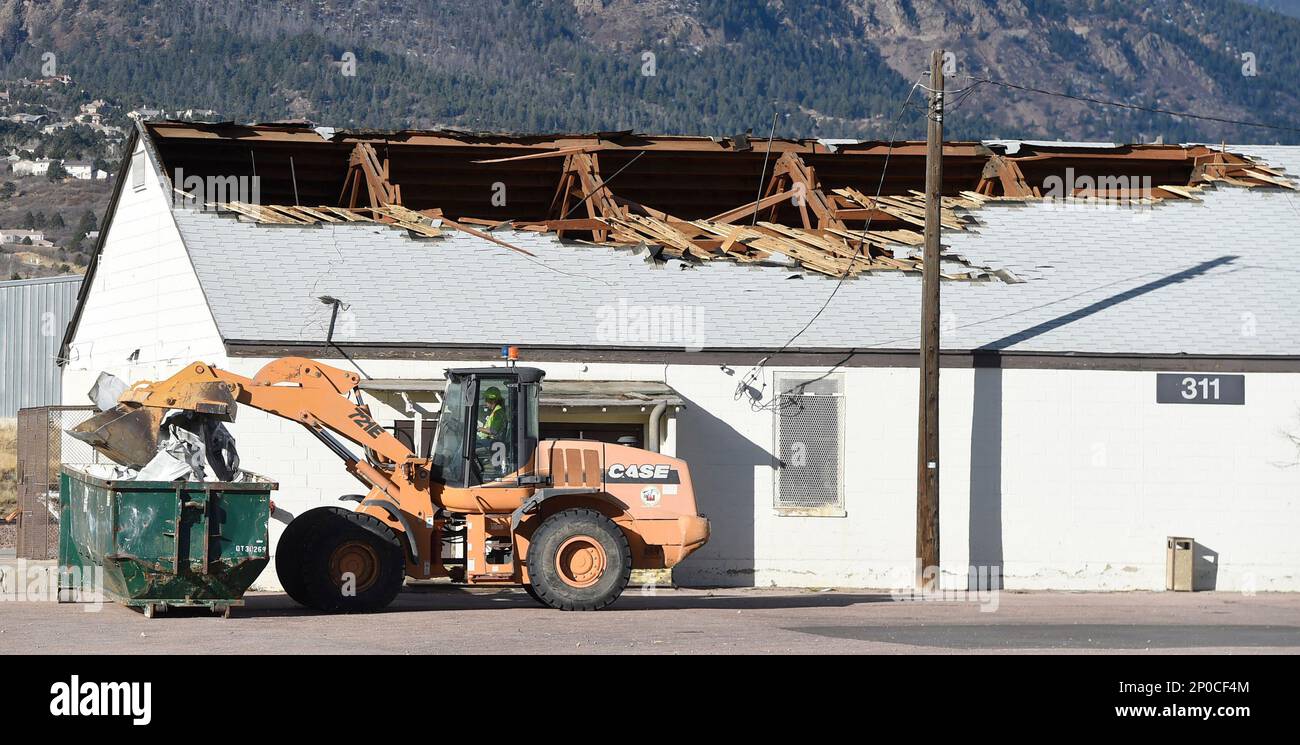 A front end loader moves debris from high winds into a dumpster located ...