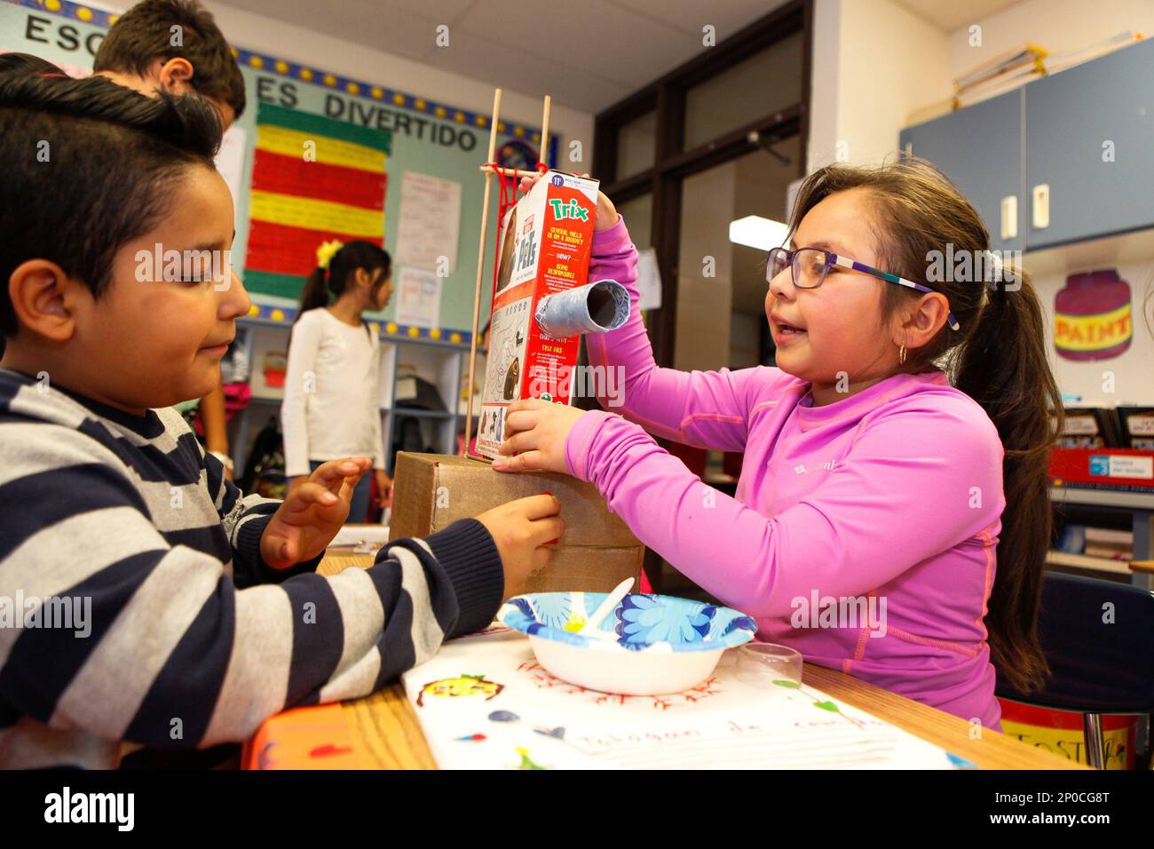 Marina Rivera, 8, shows Derrick Vasquez, 9, how her cereal dispenser ...