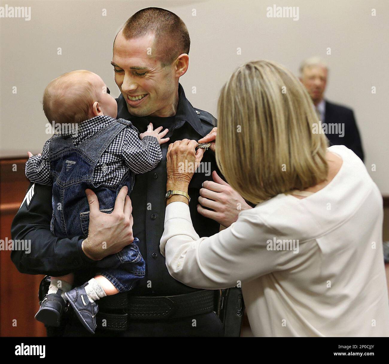 Alton, Ill., Police Sgt. Jarrett Ford, smiles at his son, Brady, as his ...