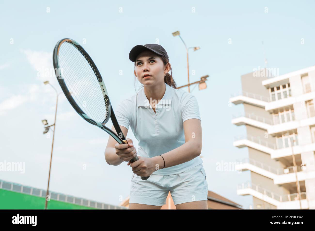 Bottom view of a female tennis athlete concentrating holding racket ...