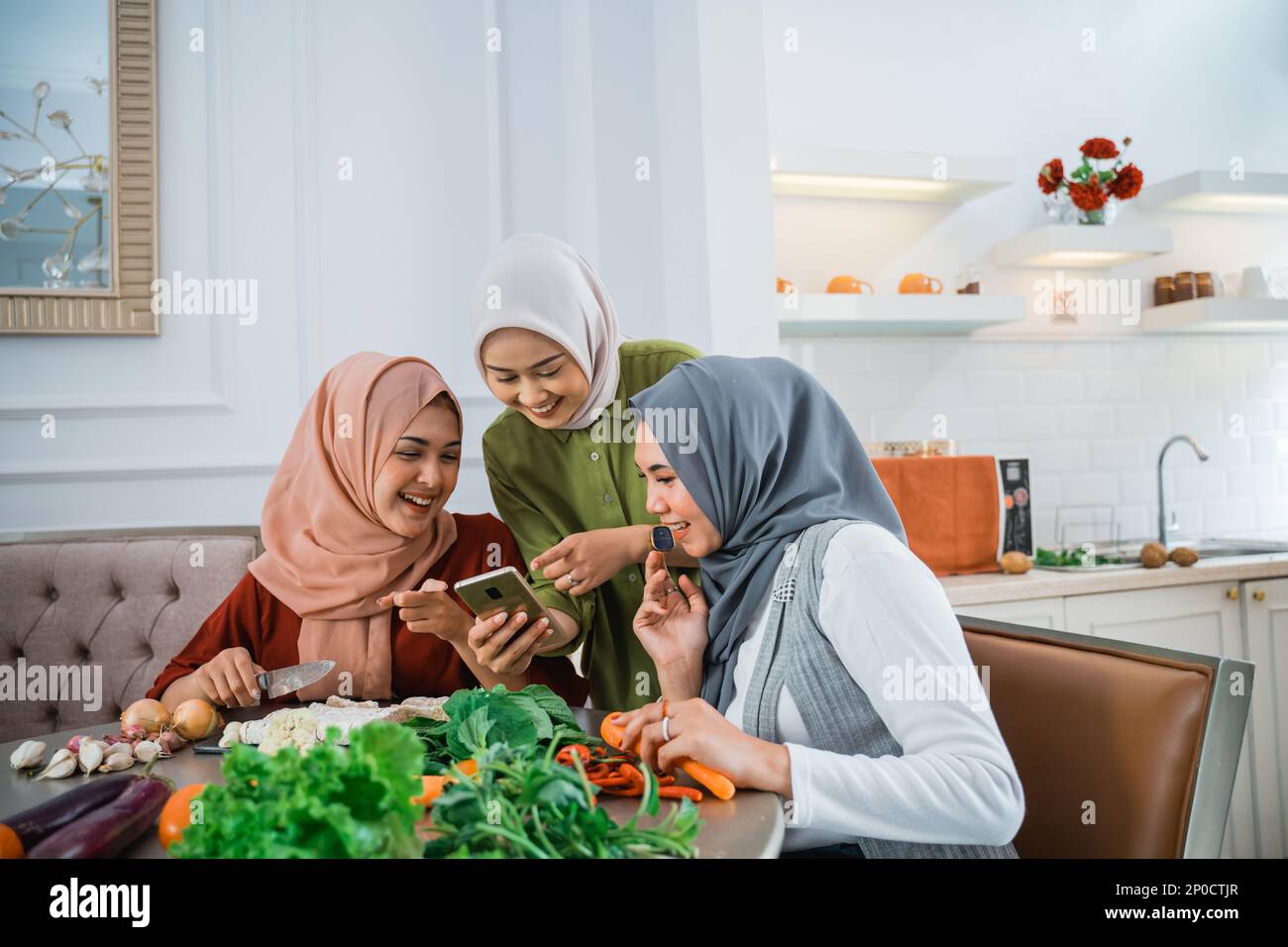 woman with hijab cooking in the kitchen while looking at internet Stock ...