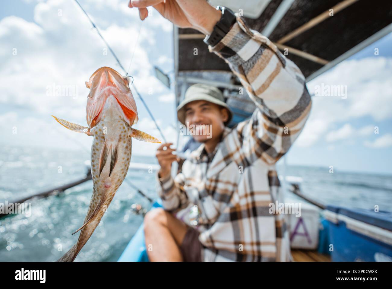 large grouper caught by an angler with a fishing rod Stock Photo - Alamy