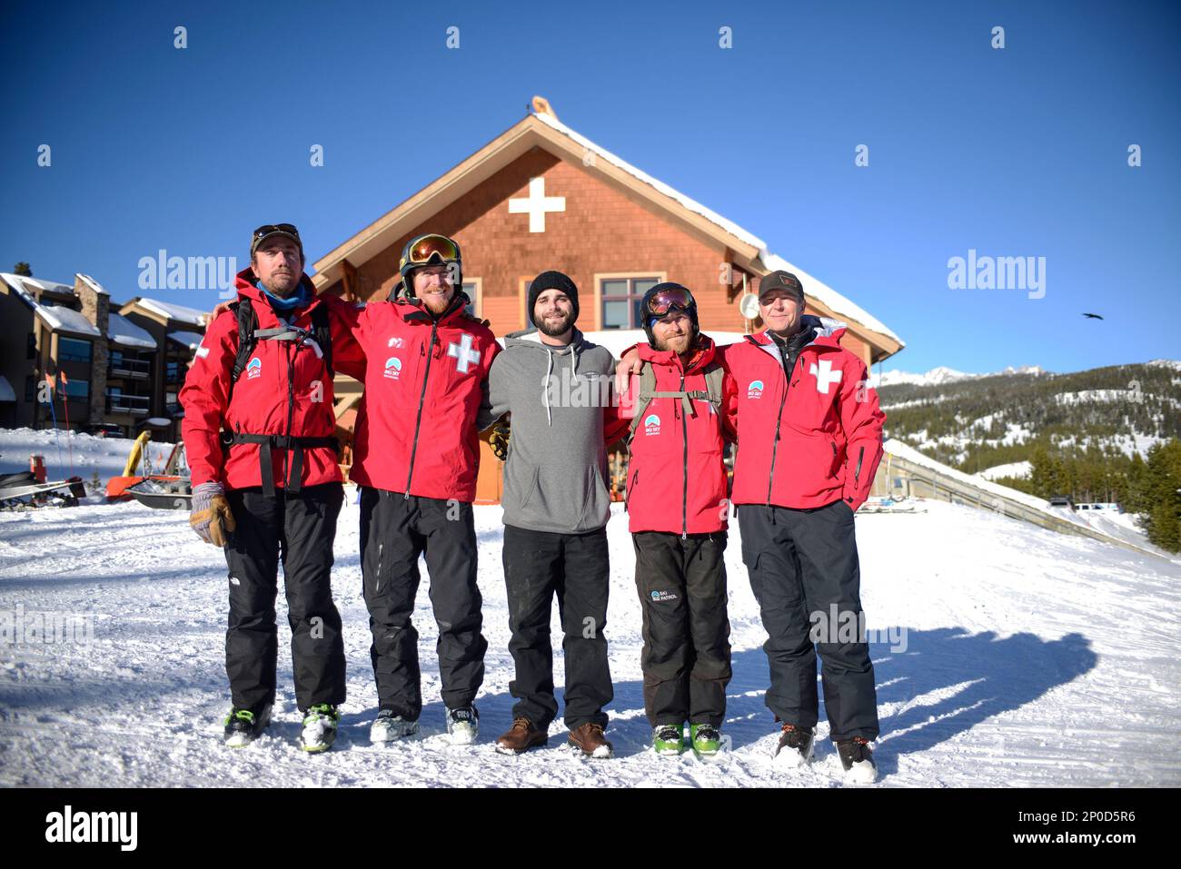 Nicholas Rennspies, center, stands with the four of the ski patrollers ...