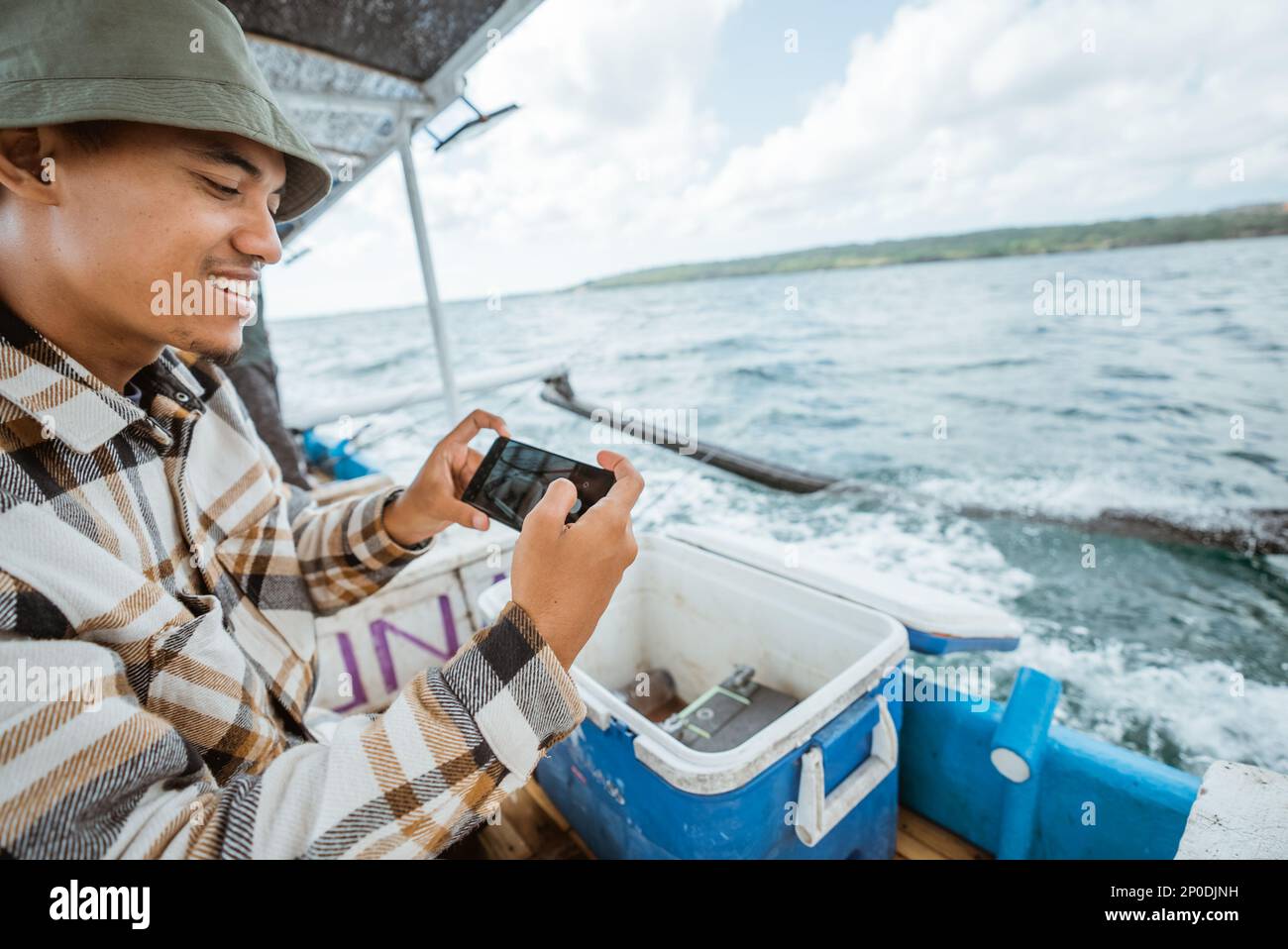 angler takes a photo of the box's fish with phone Stock Photo - Alamy