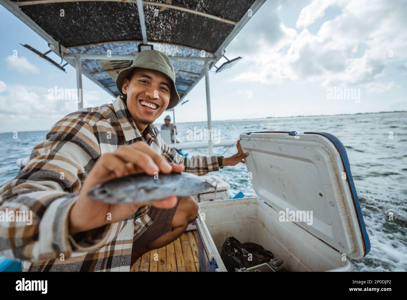 smiling angler showing fish for sea fishing in a boat Stock Photo - Alamy