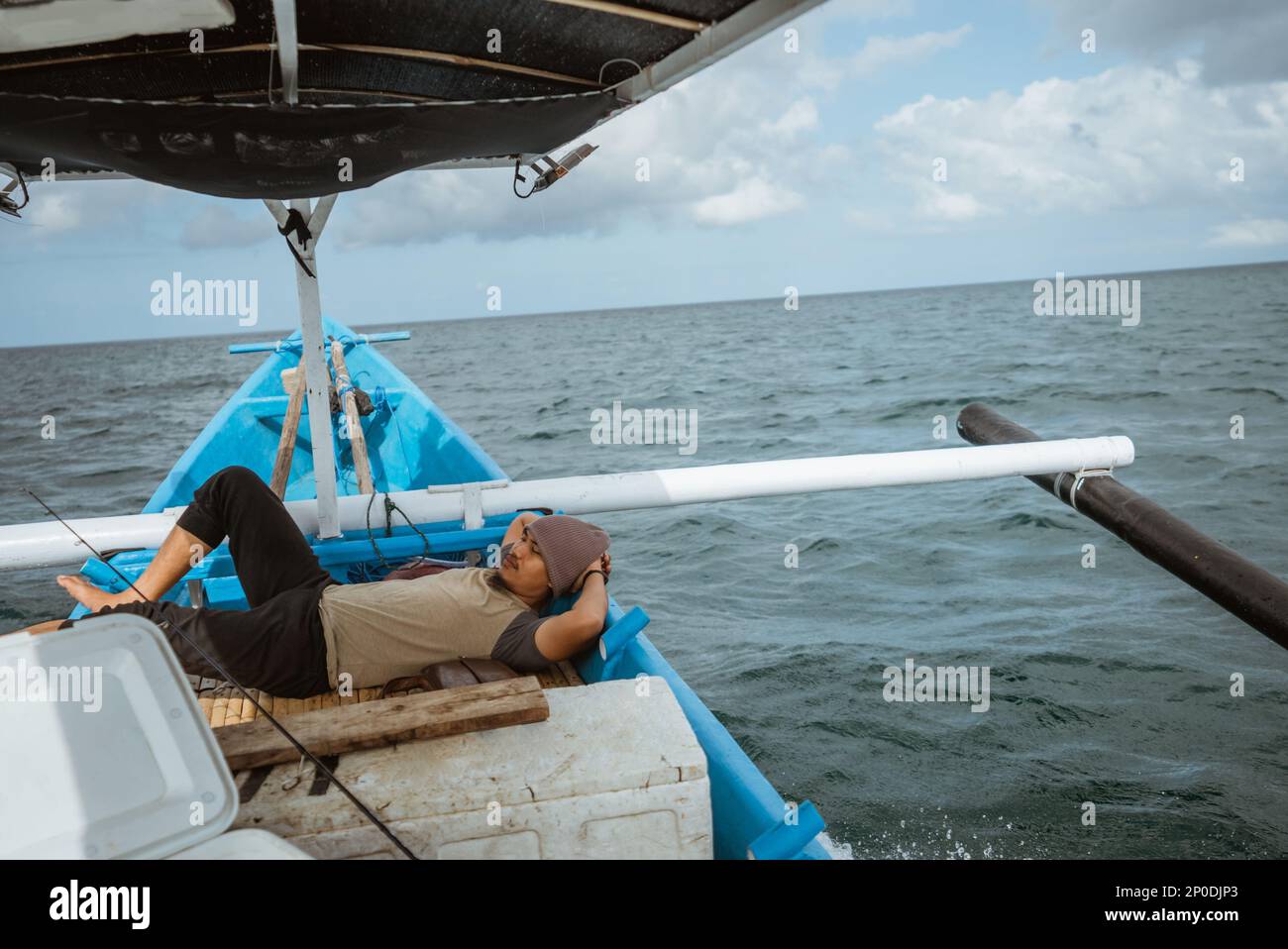 fisherman lying down while resting on a small fishing boat Stock Photo ...