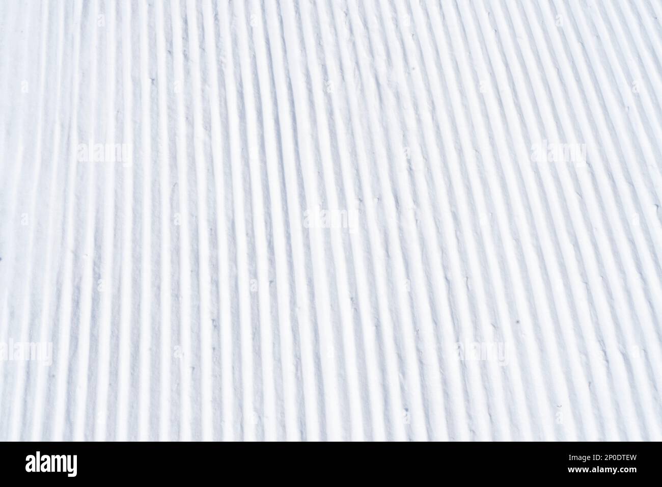 Close up of groomed tracks on a slope in a downhill ski resort. Close ...