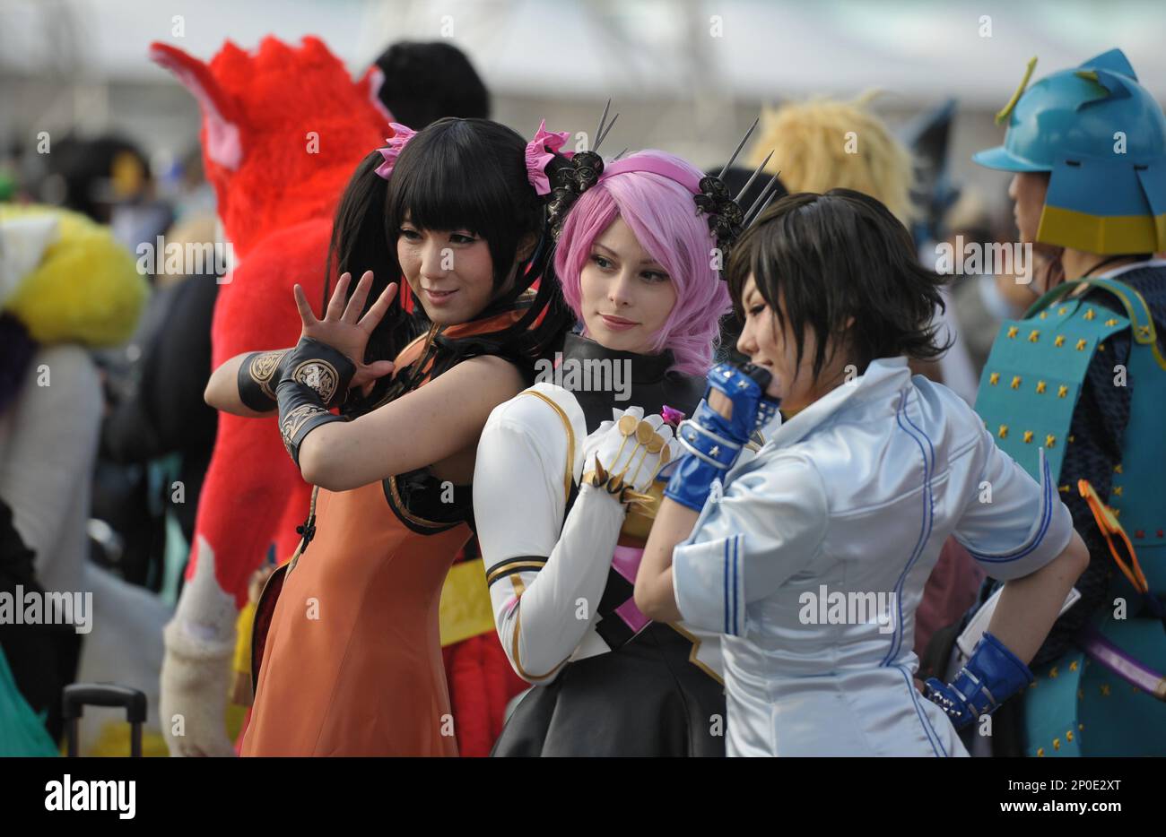 Participants as cosplayers pose for a photographer during “Comic market ...