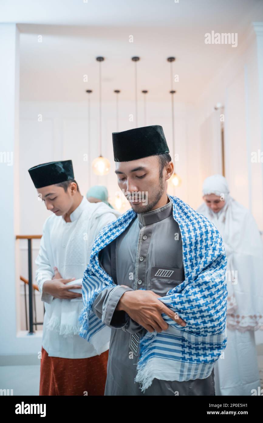Asian men in caps perform iftitah prayer movements during prayers Stock ...