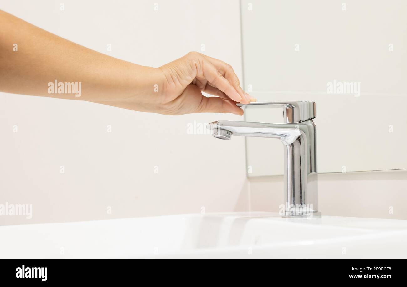 close up Woman open pull chrome faucet washbasin to washing hand soap ...