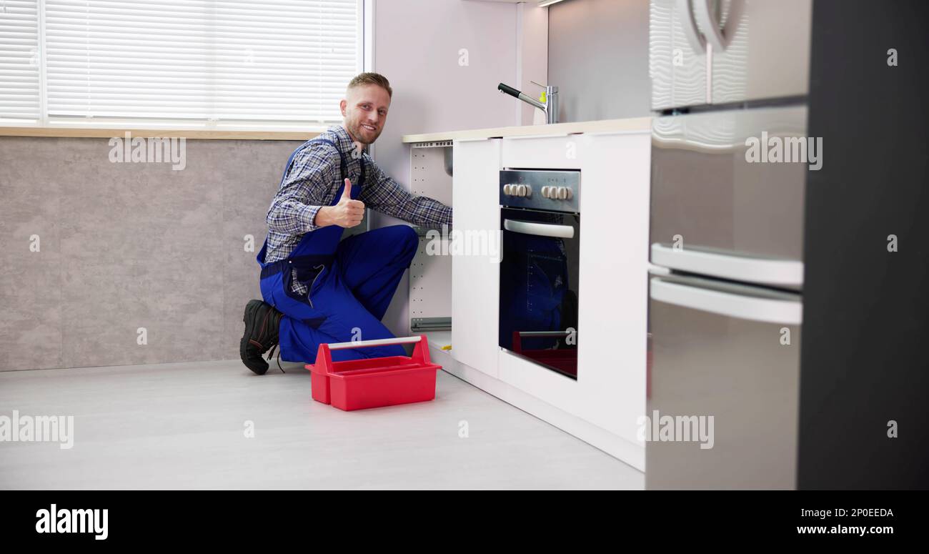Plumber Cleaning Drain And Pipe In Kitchen Stock Photo - Alamy