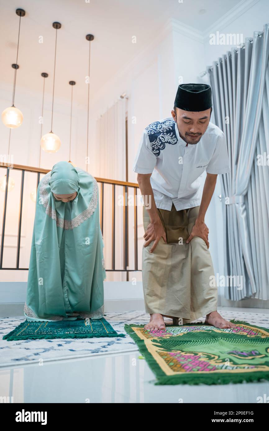 Asian Muslim man leads prayer with woman during Ruku movement Stock ...