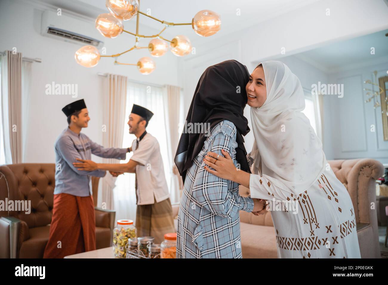 two women in hijab embracing during visiting family eid celebration ...