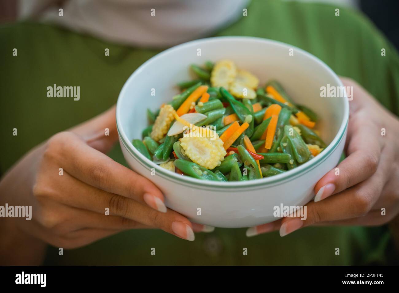 Muslim woman's hand carries bowl of vegetable dish for iftar Stock ...