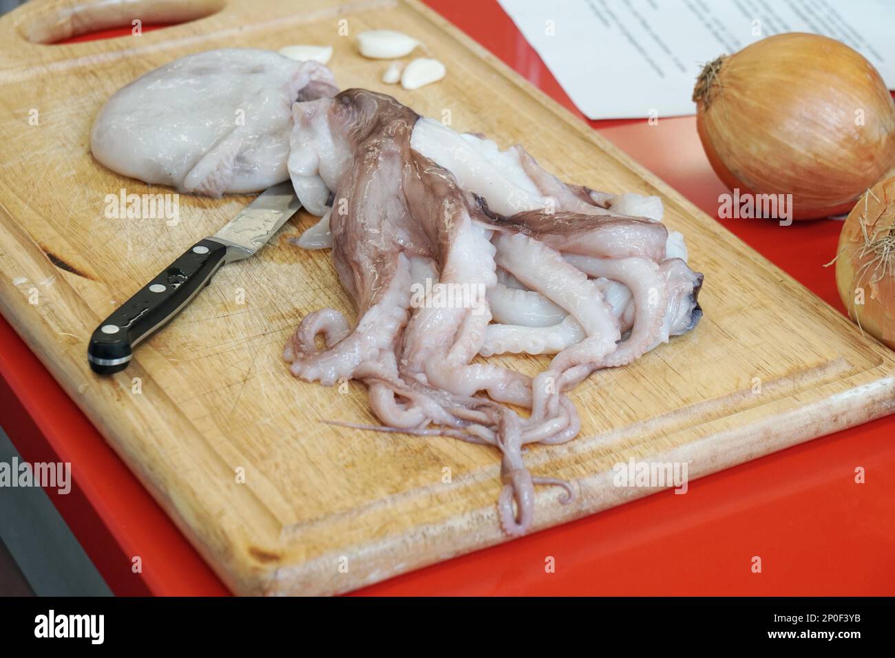 preparing fresh raw octopus or squid or calamari on wooden cutting ...