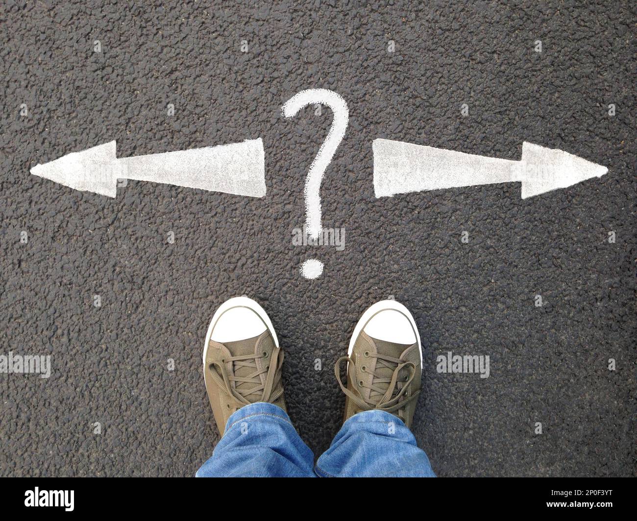 feet in canvas shoes standing on asphalt from personal perspective ...