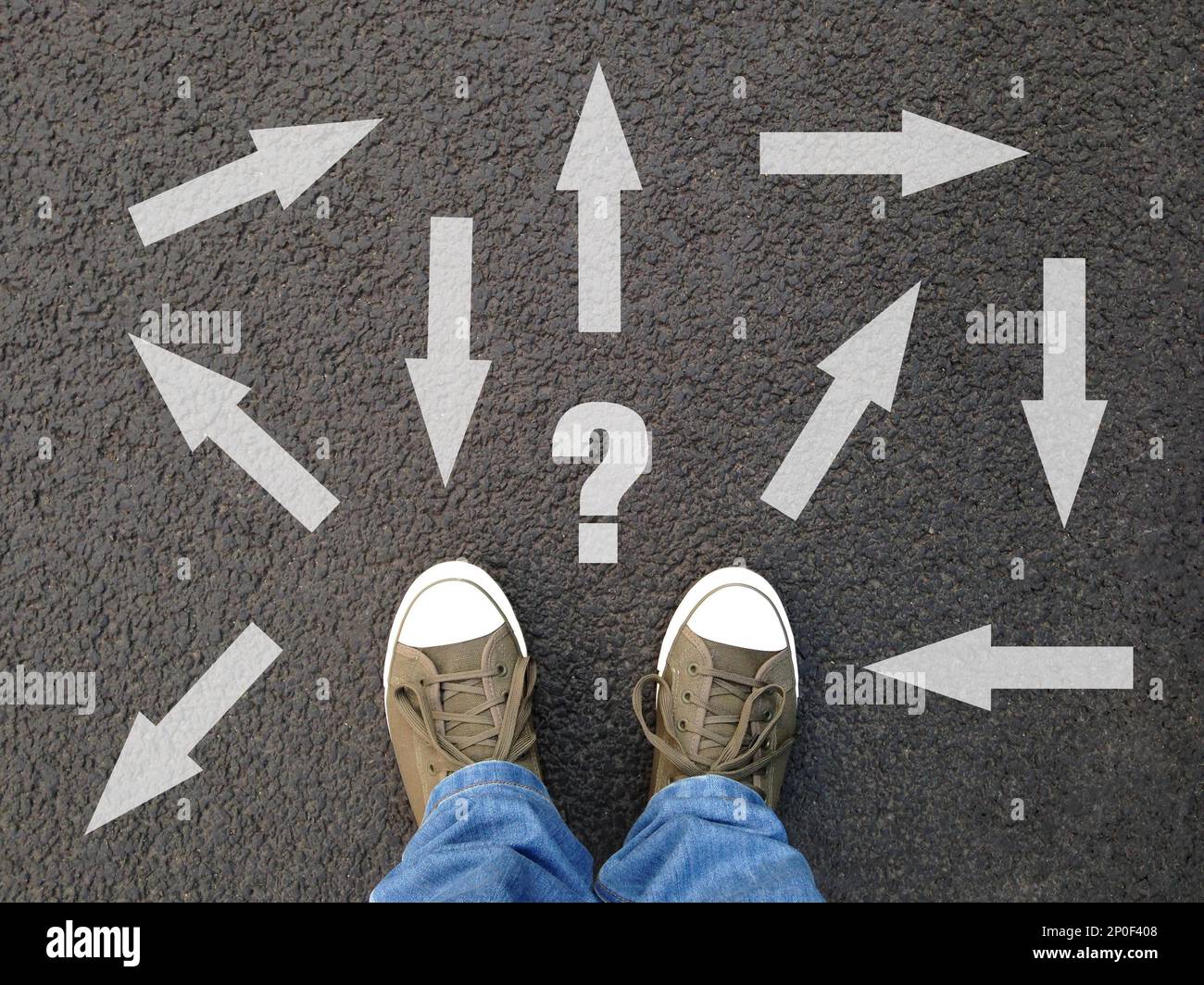 feet standing on asphalt with multitude of arrows in different ...