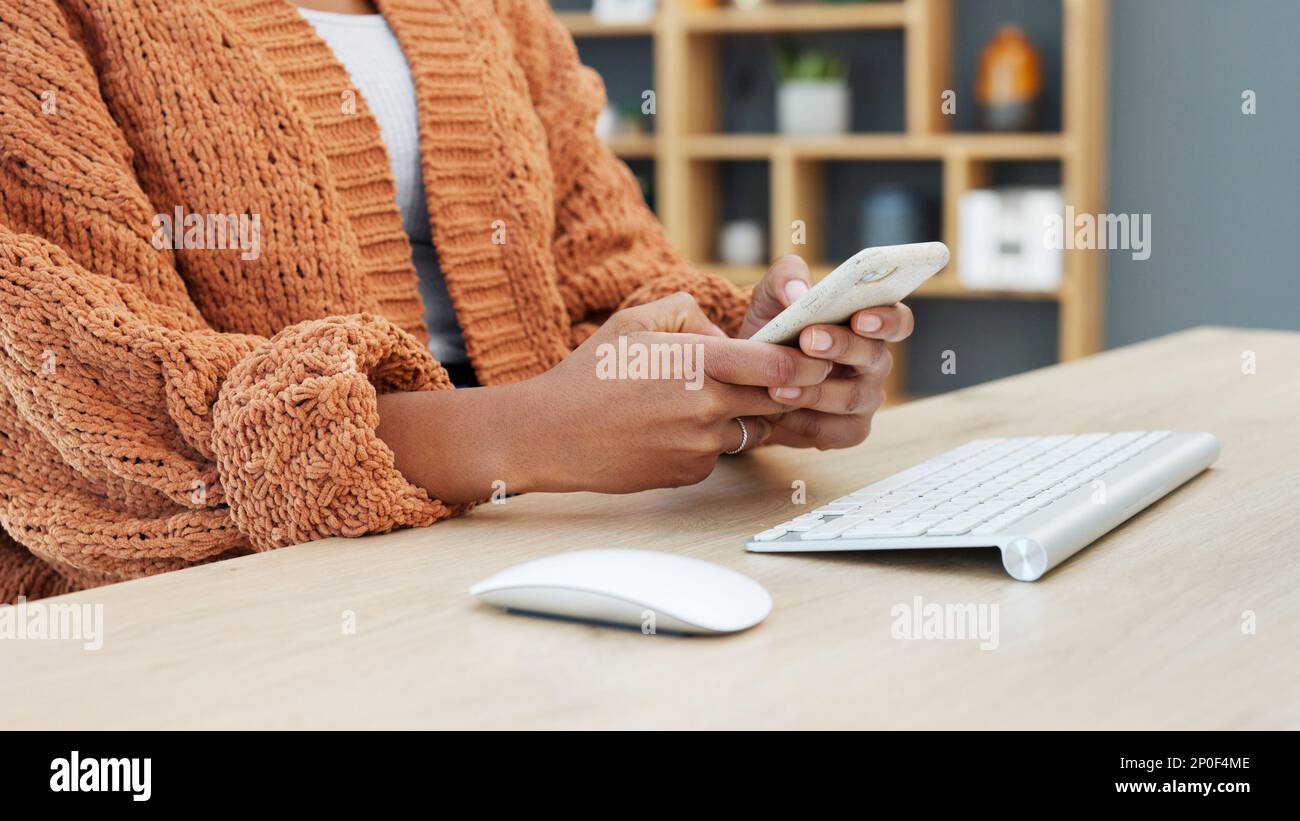 Women using a phone to type a text while working as a web developer for ...