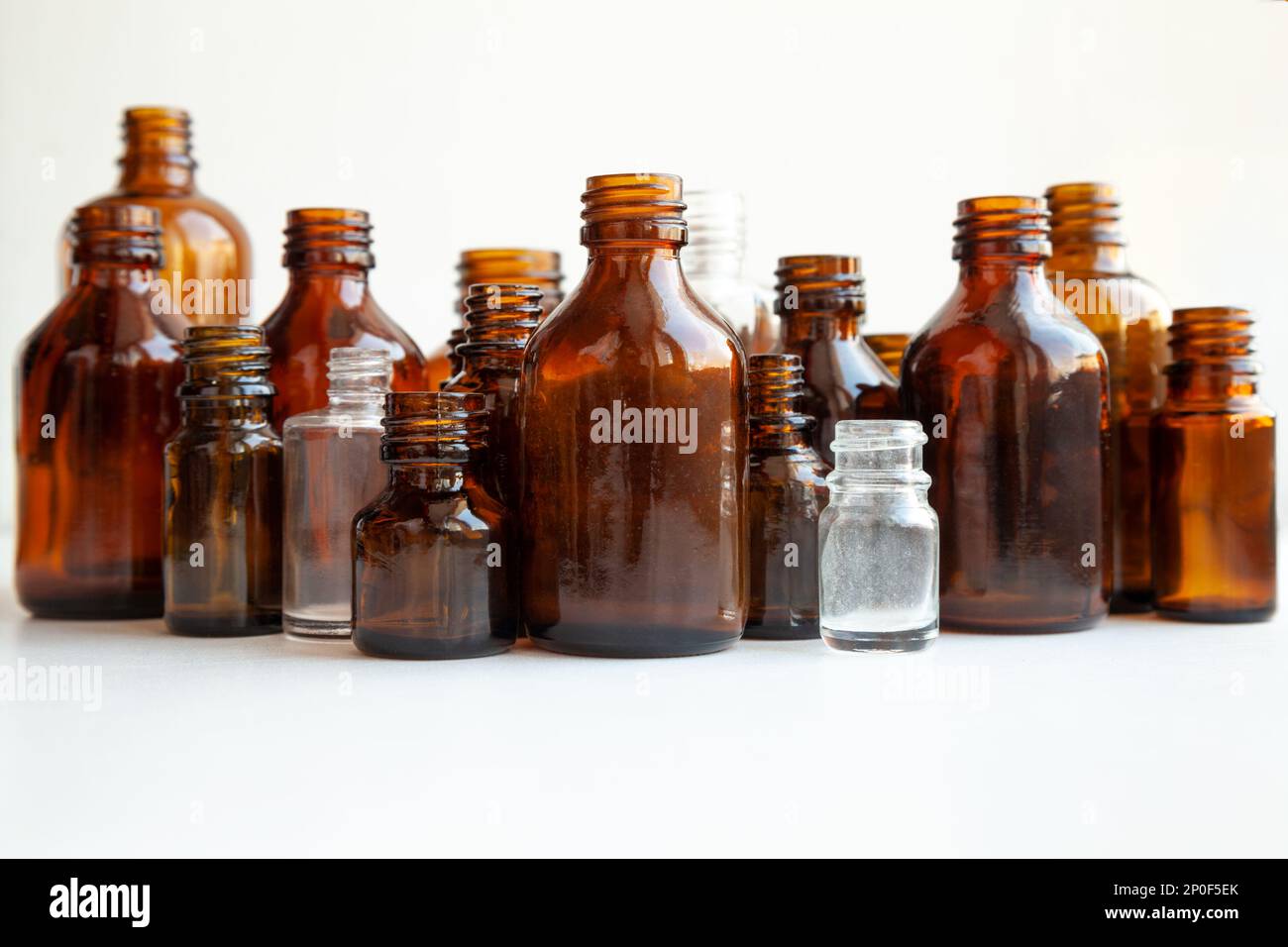 Group of various medical vials isolated on white. Many small brown ...