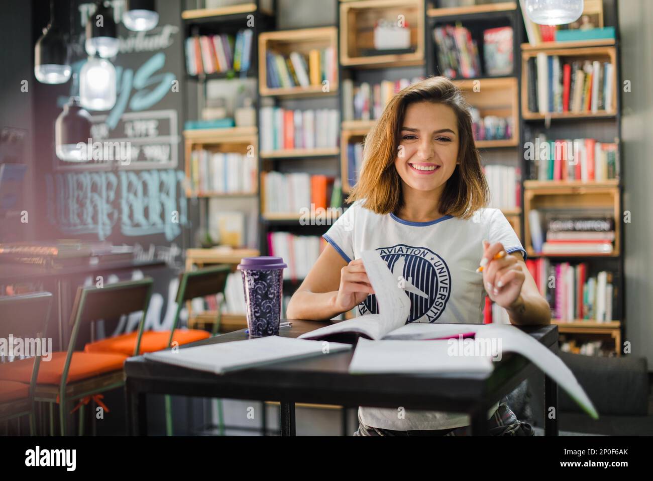 Smiling girl sitting table hi-res stock photography and images - Alamy